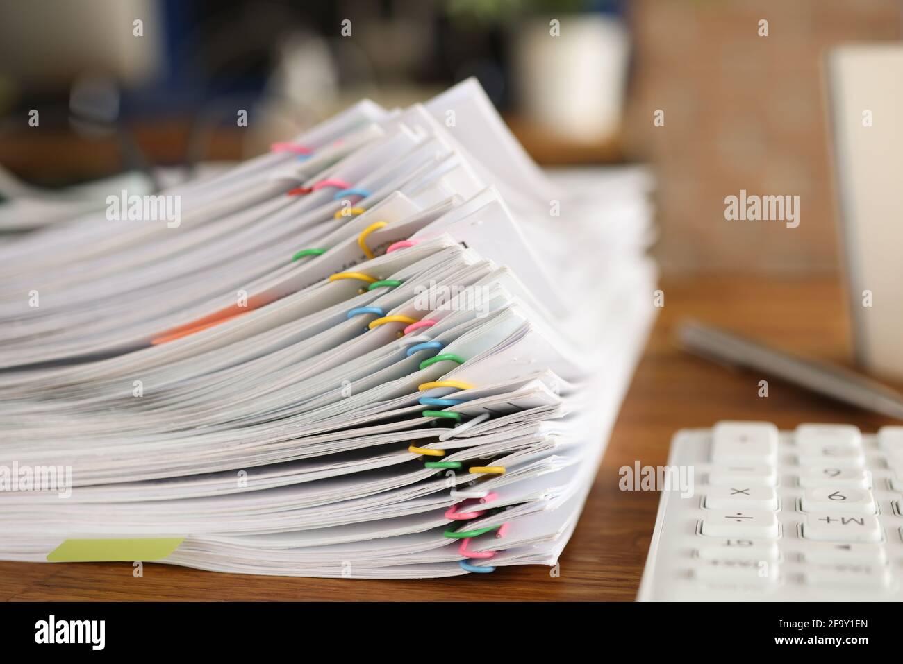 Lot of documents fastened with multicolored paper clips lying on table ...