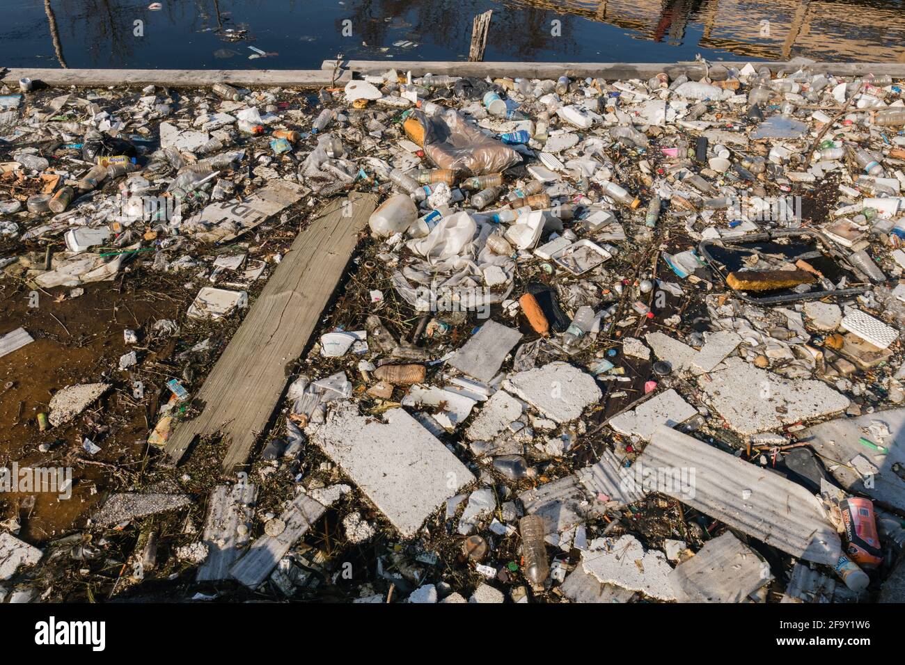Garbage and trash collects in urban river causing a back up of ...