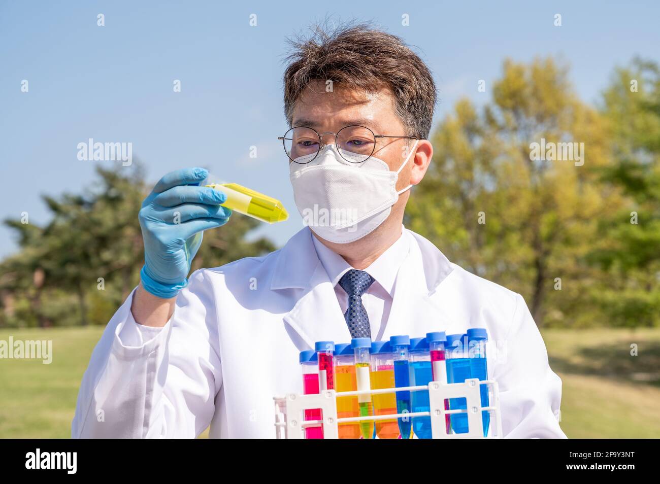 Portrait of a middle-year Asian male scientist wearing a white lab gown ...