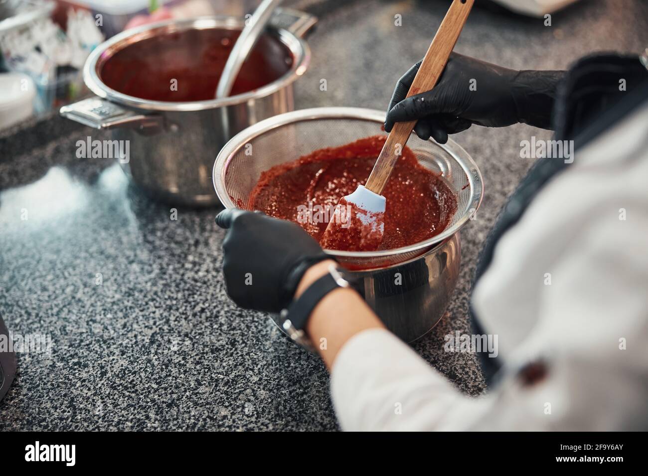 Skilled pastry chef preparing sweet filling in the kitchen Stock Photo ...