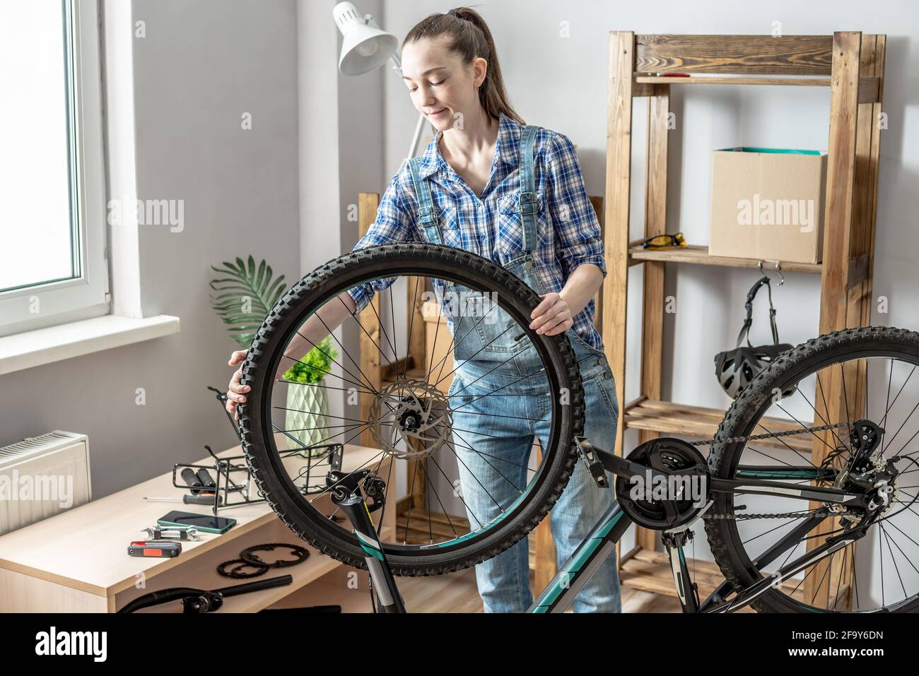 A woman is performing maintenance on his mountain bike. Concept of ...