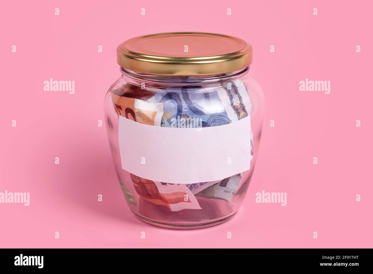 Euro banknotes in glass money jar with blank label, financial, saving ...