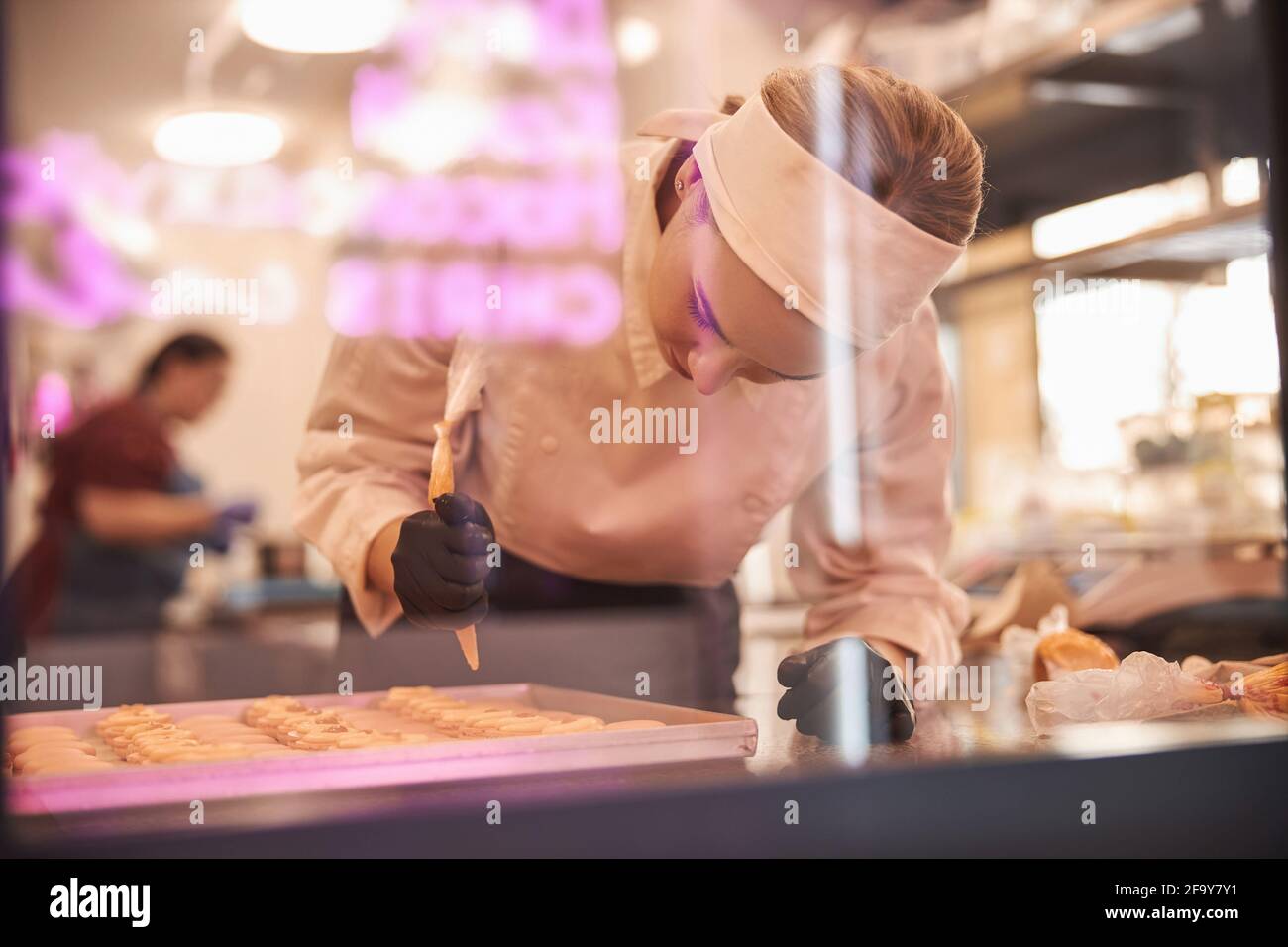 Inspired pastry chef making macarons in stylish modern kitchen space ...
