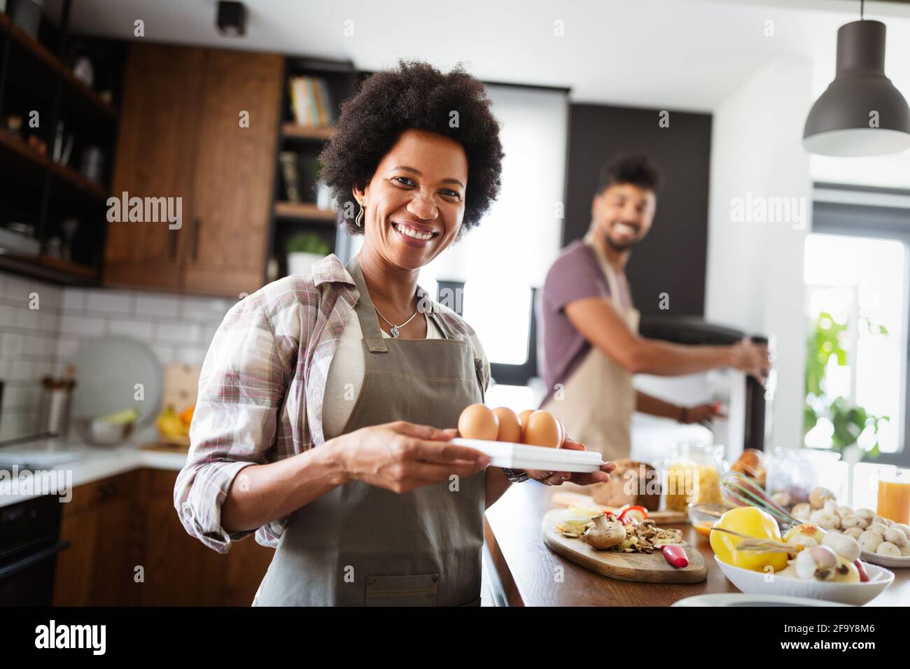 Beautiful couple are hugging and smiling while spending time in kitchen ...