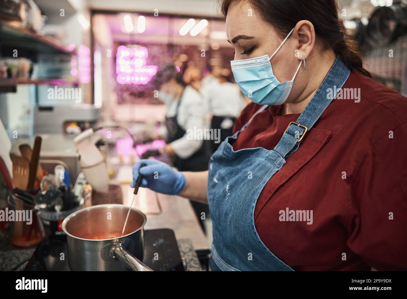 Professional kitchen staff following food handling safety protocols ...