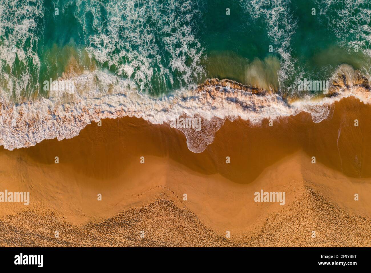 Aerial view of ocean waves and sandy beach. Top view of sea coast with ...
