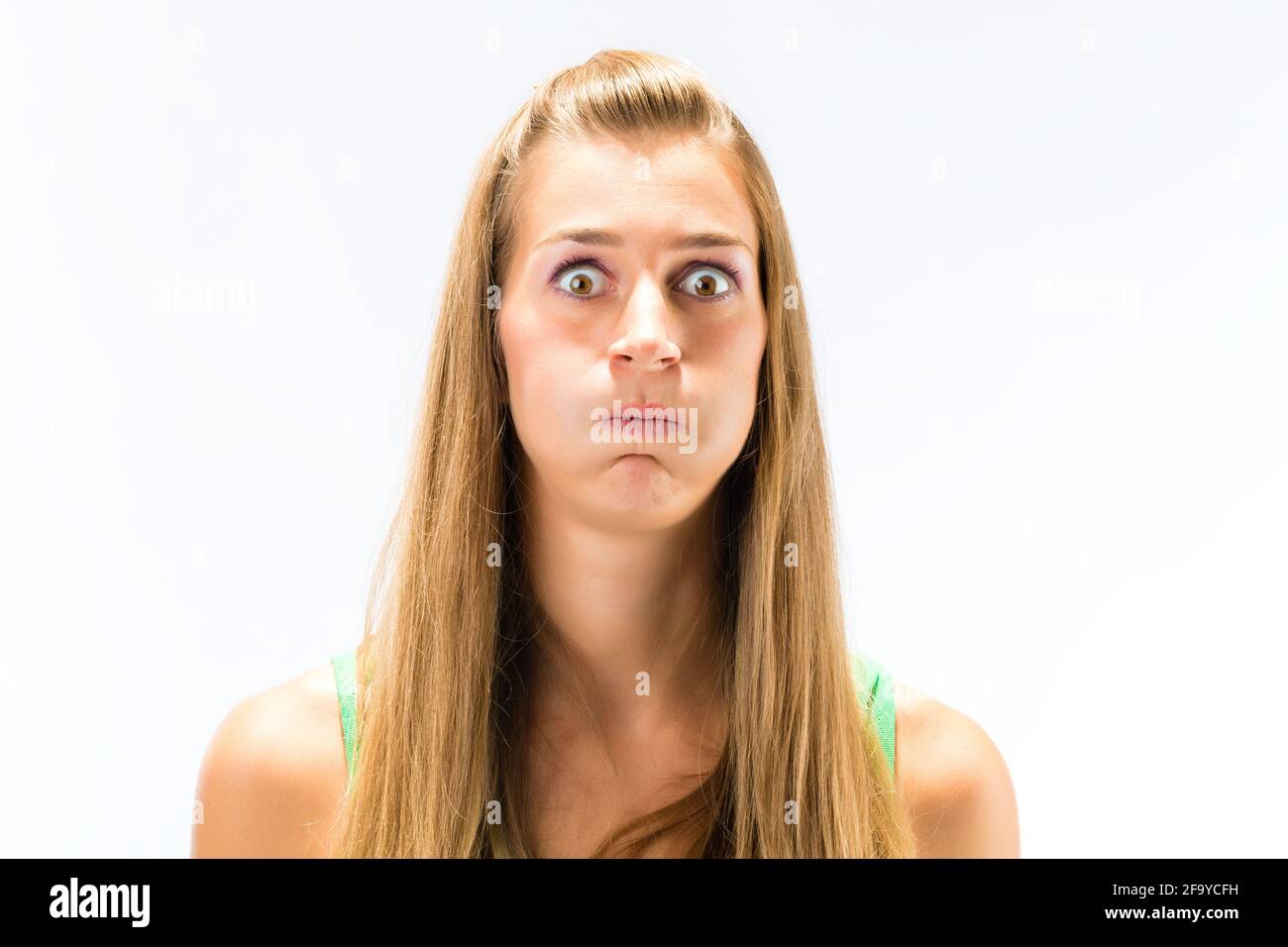 Portrait of blonde young woman blowing her cheek against white ...