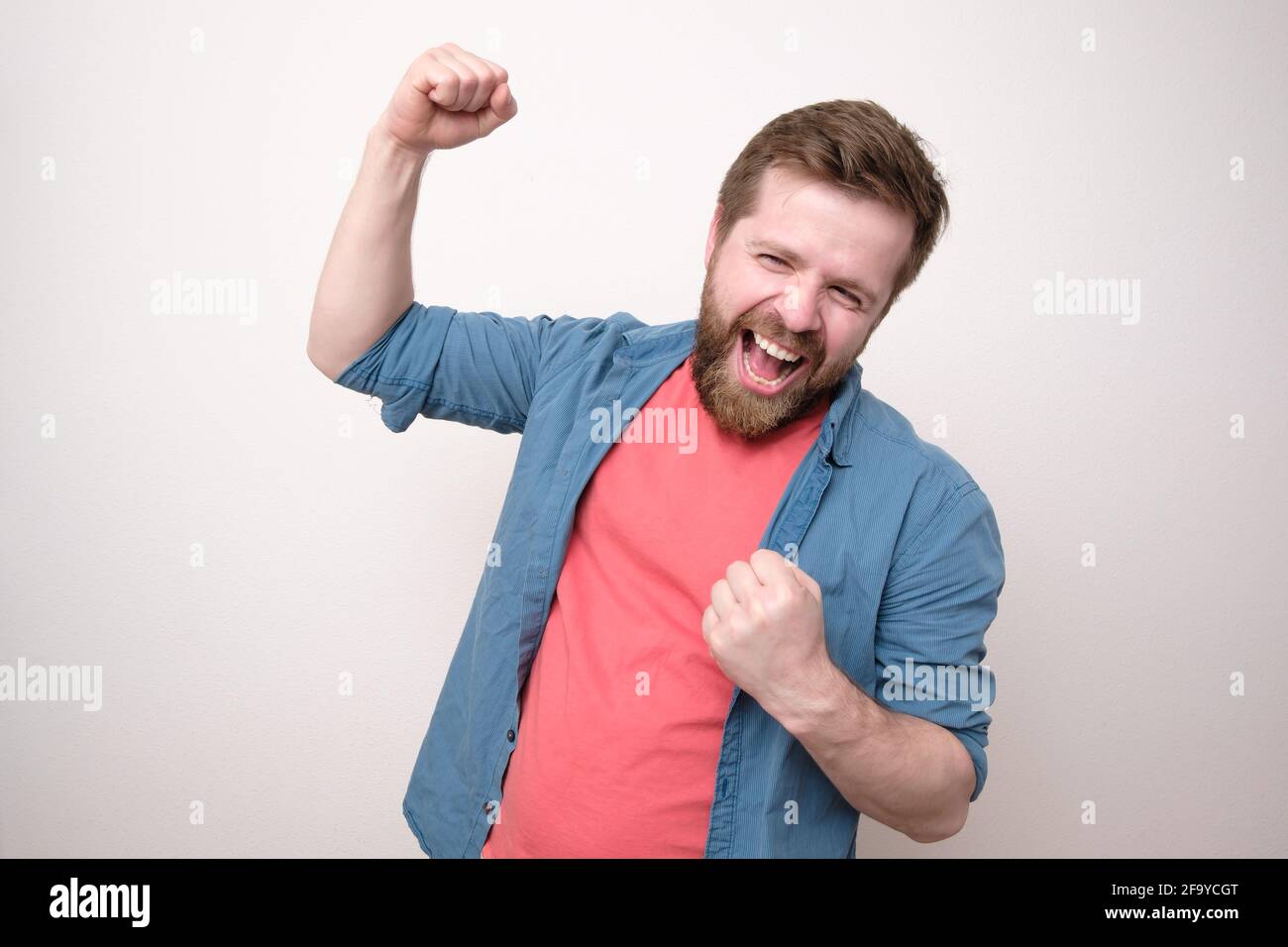 Cheerful, happy man, he laughs and makes a joyful hand gesture. Winning ...