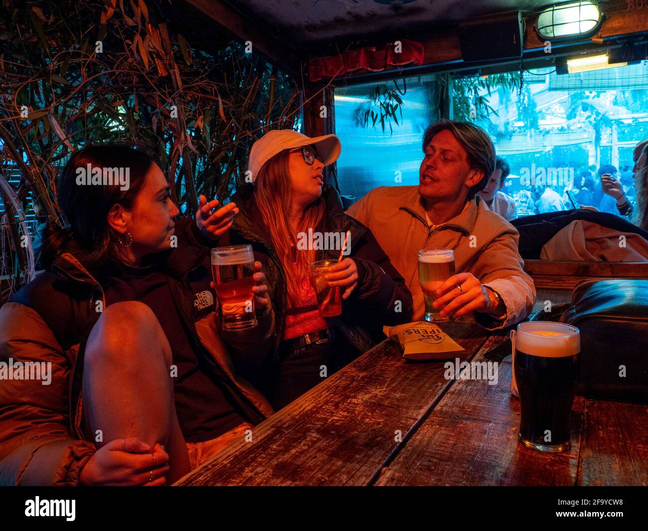 FRiends keep warm in a heated booth at an east London pub Stock Photo ...