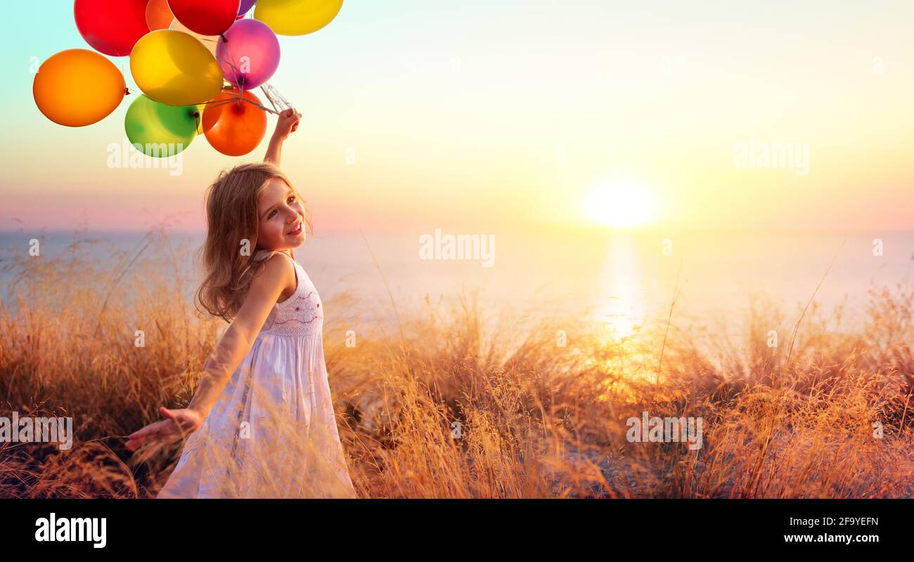 Girl flying balloons in sky hi-res stock photography and images - Alamy