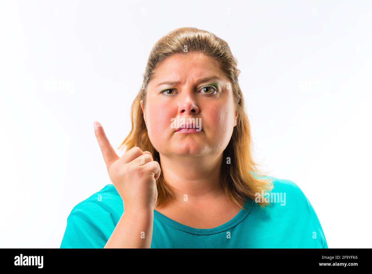 Portrait of serious woman pointing her finger upward Stock Photo - Alamy