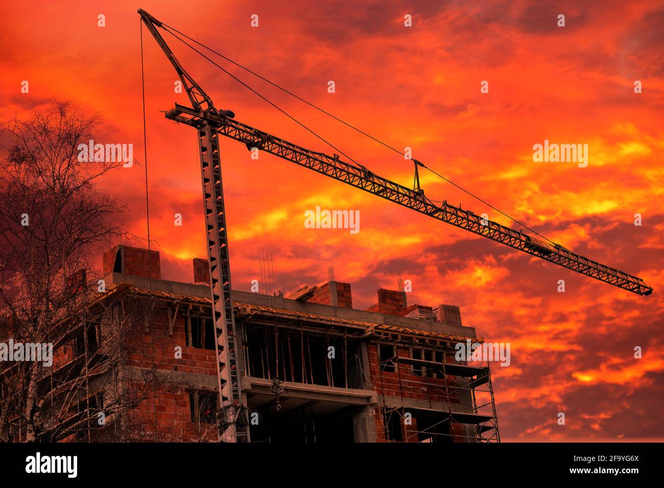Dramatic and moody shot of a crane in front of a brick-walled building ...