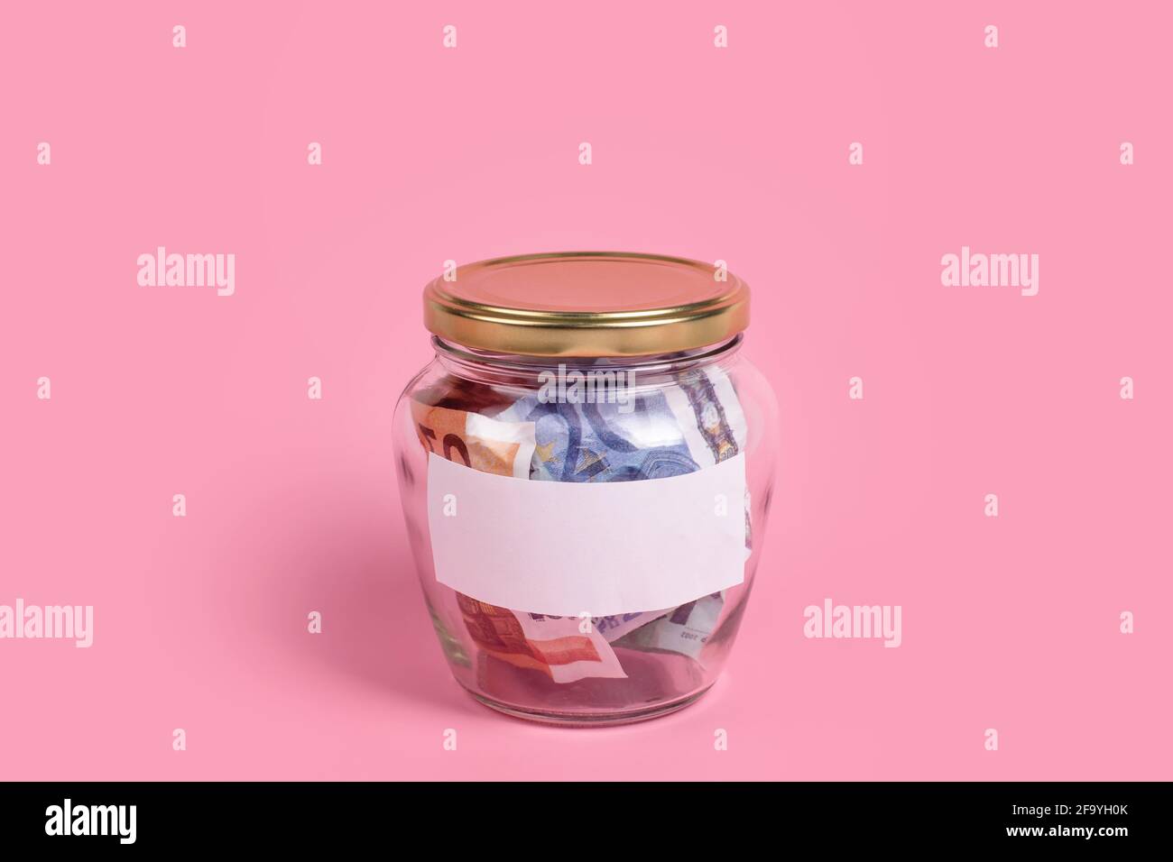 Euro banknotes in glass money jar with blank label, financial, saving ...
