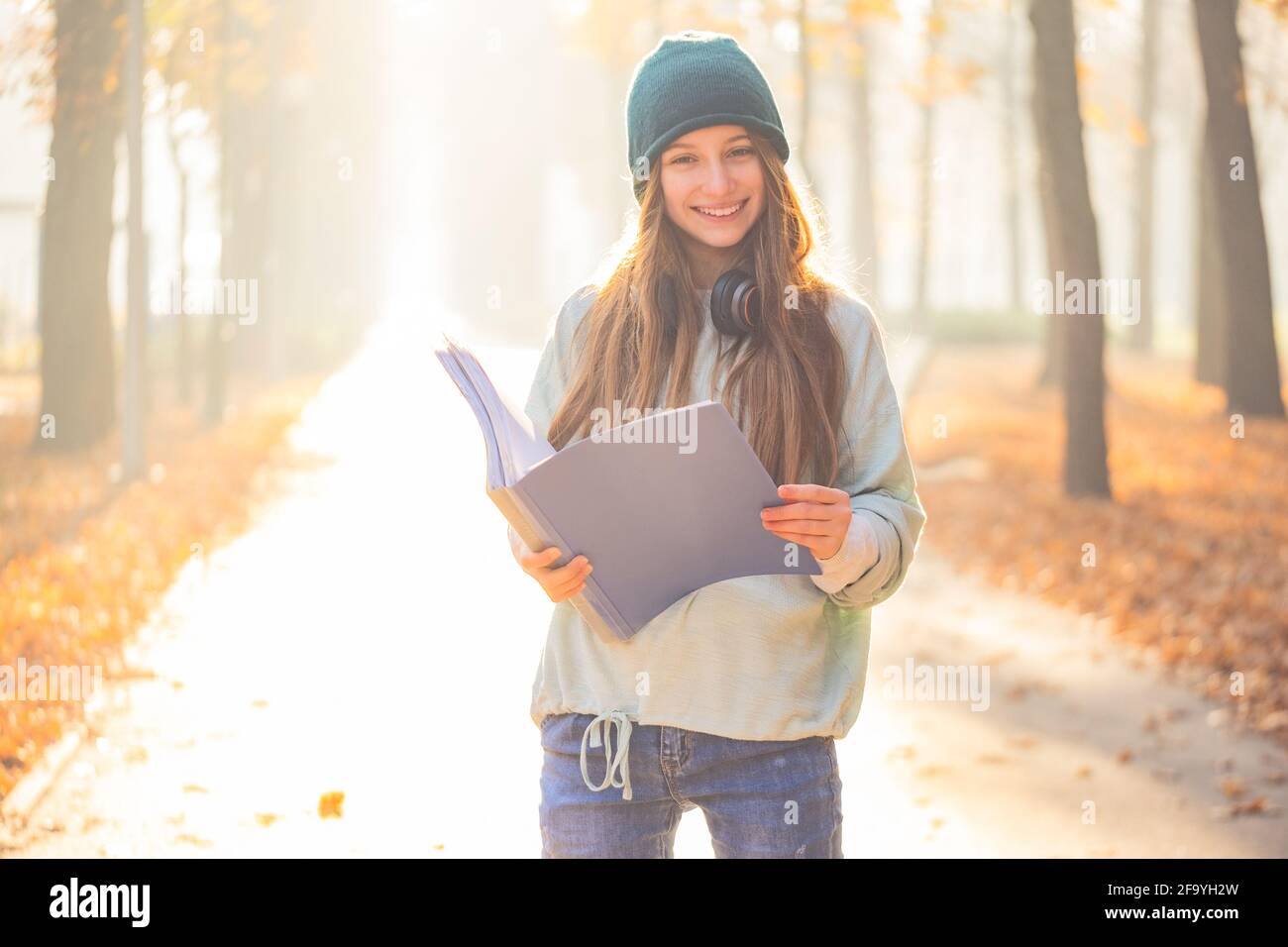 Cute teenage girl reading notes in park Stock Photo - Alamy