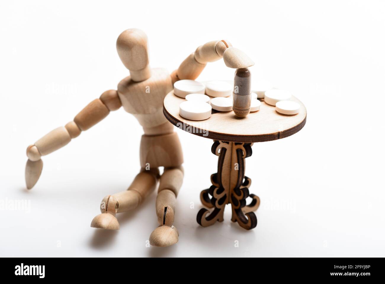 Medication regimen. Human wooden dummy near table with medicines. Tips ...