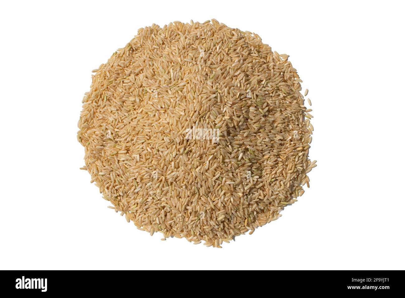 mound pile of long grain brown rice on white table surface in natural ...