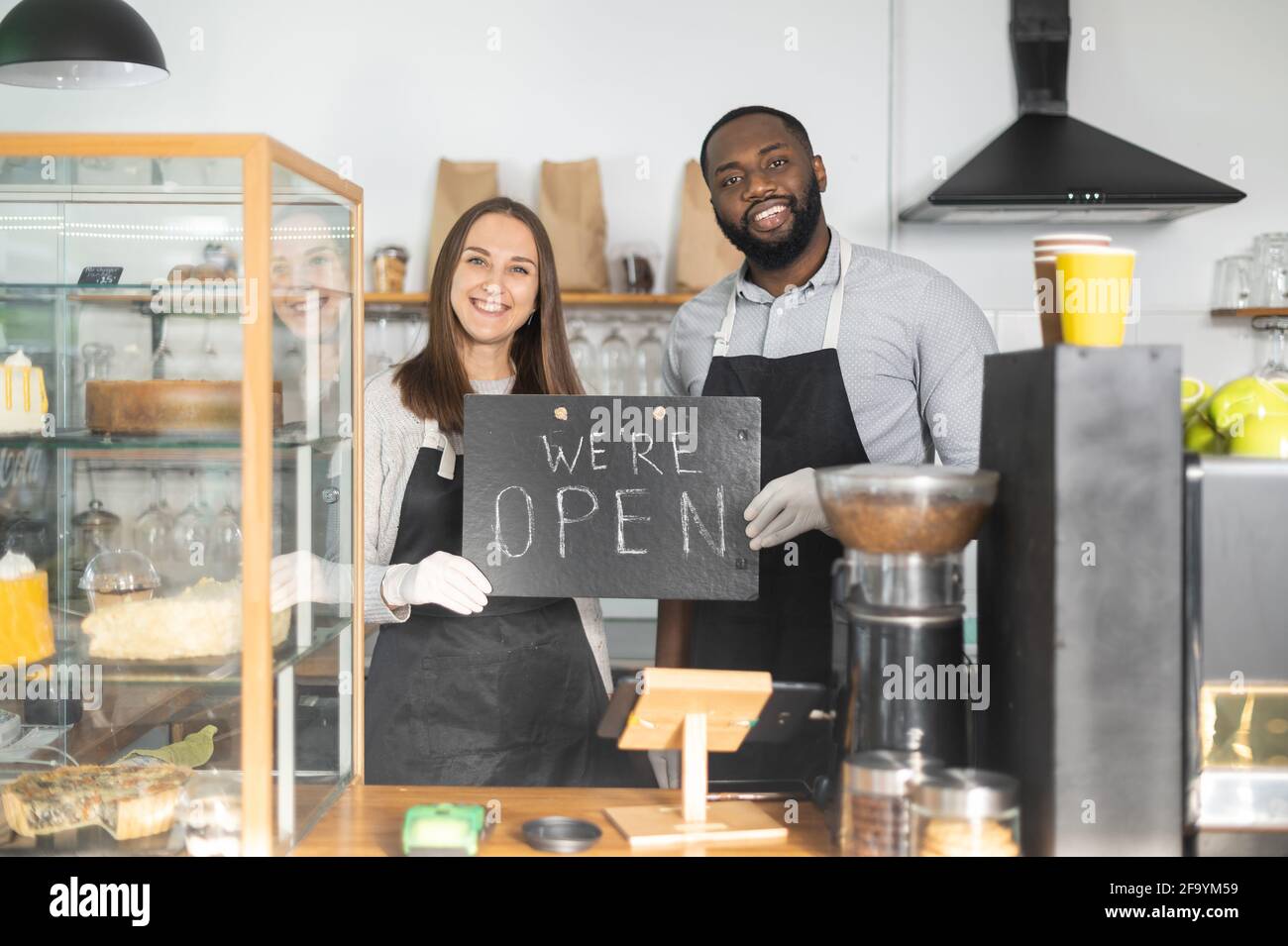 Cheerful caucasian female barista and african american male barista ...