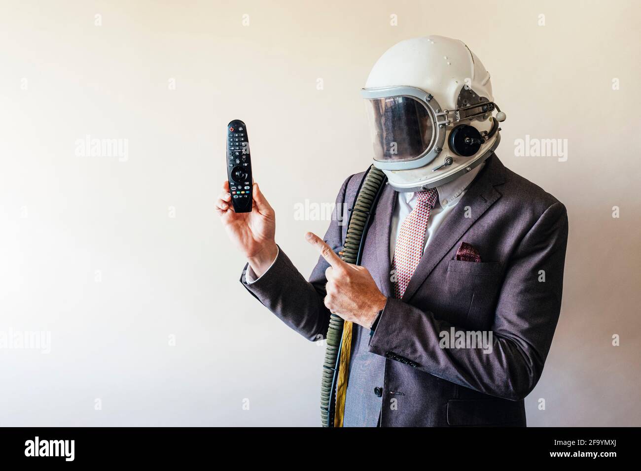 Businessman with astronaut helmet holding a television remote Stock ...