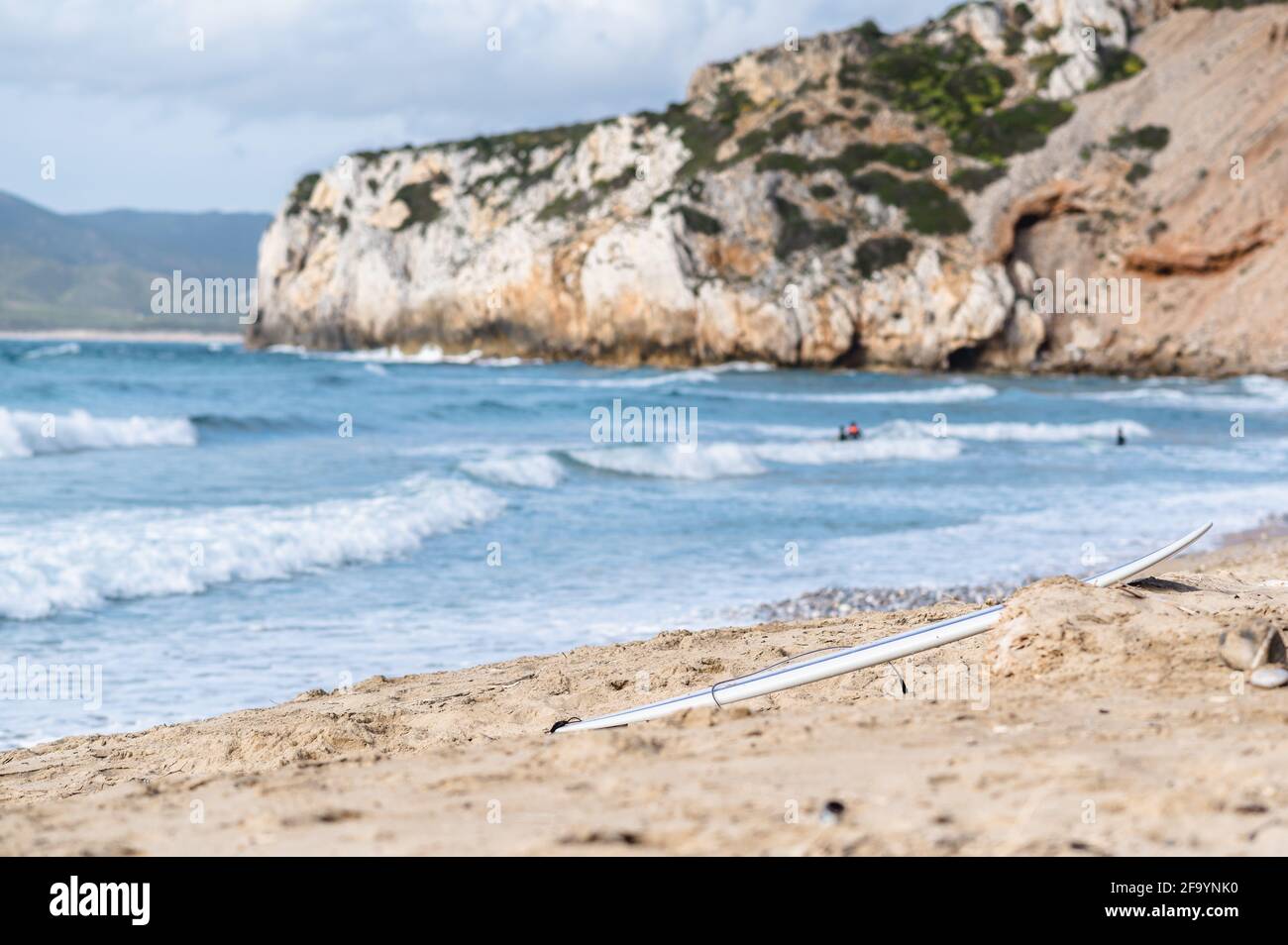 Close-up of a surfboard lying down on a sandy beach with blurred ...