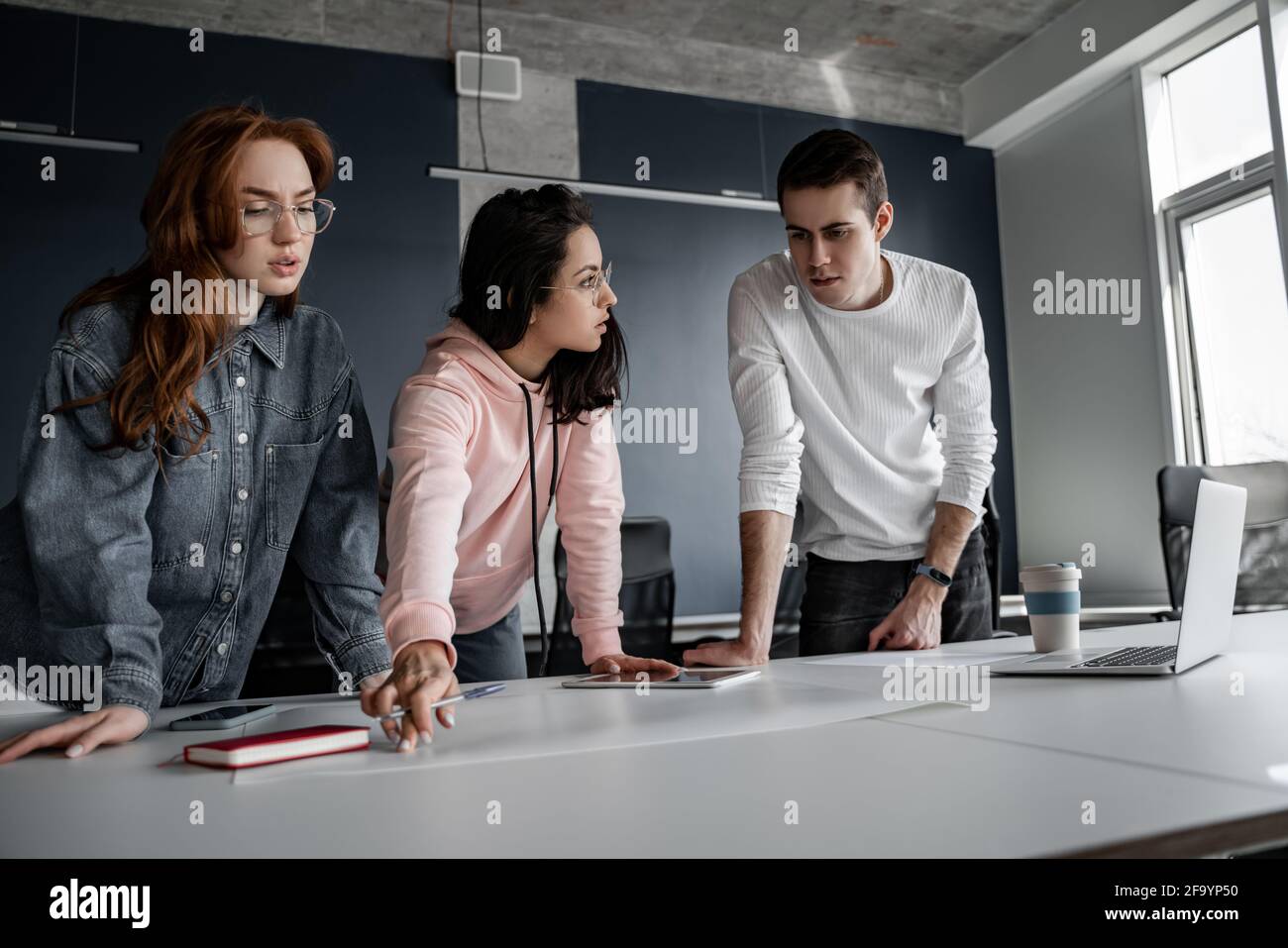 young students looking at paper with project on desk Stock Photo - Alamy