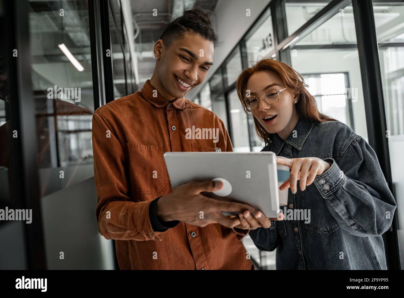 African american student using digital tablet near classmate with ...