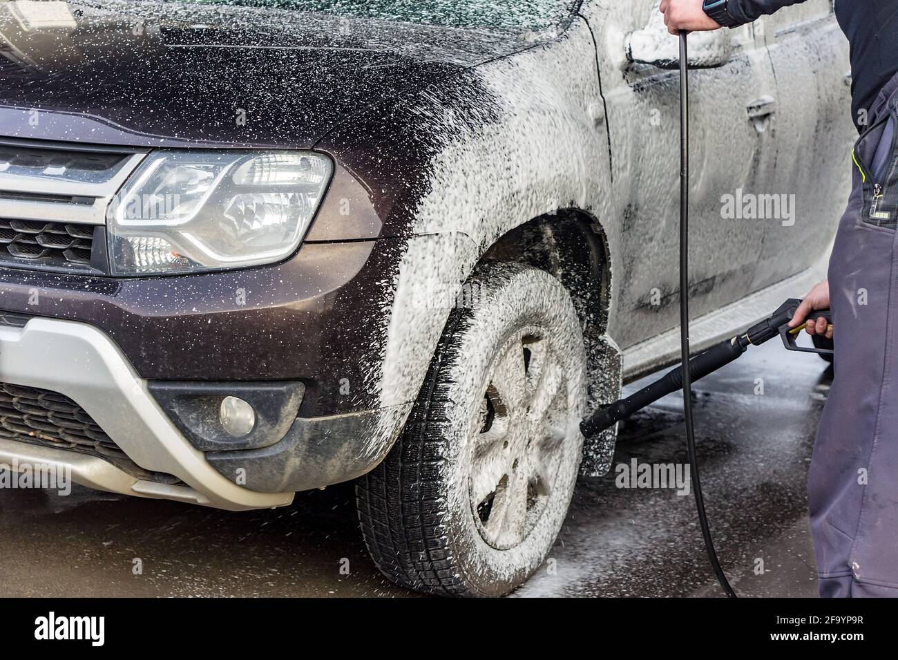 Kaliningrad region, Russia, March 1, 2020. A man washes his car. A man ...