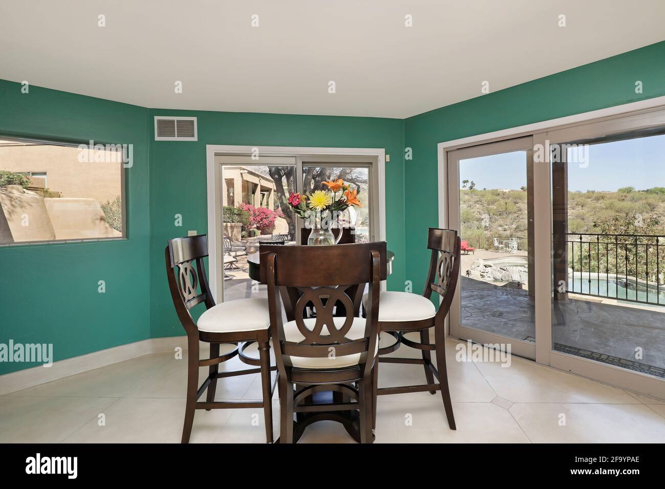 Eating area in luxury home with cocktail table and chairs and green ...
