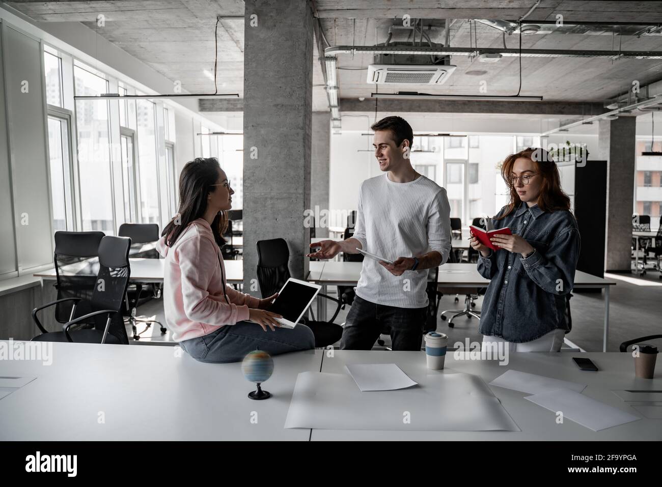 young students holding devices while discussing project Stock Photo - Alamy