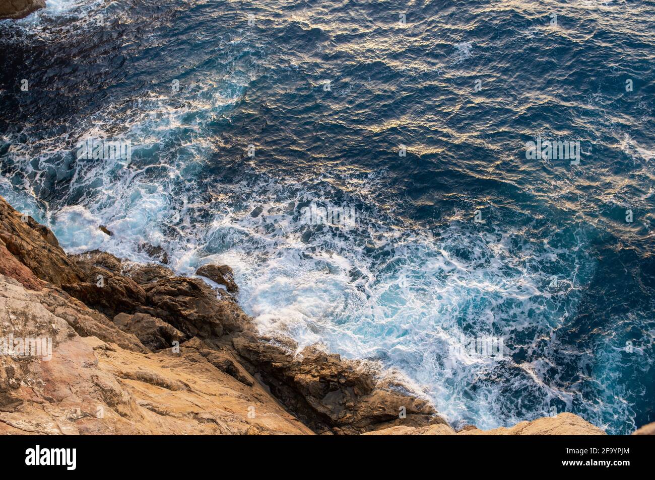 Wave breaking on the rock. View from above Stock Photo - Alamy