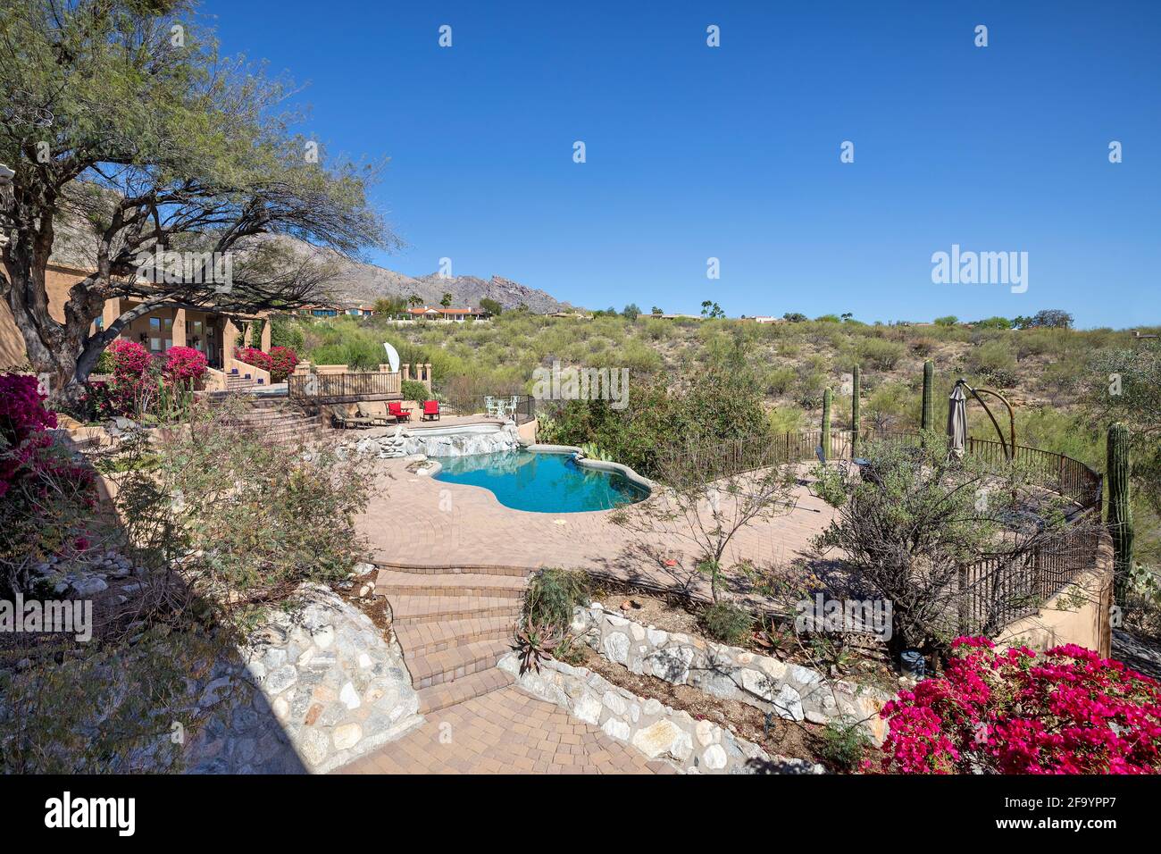 Swimming pool and terraced patio at a luxury home in a desert ...