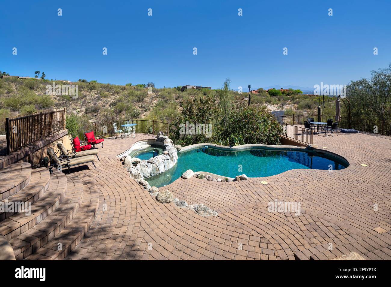 Swimming pool and terraced patio at a luxury home in a desert ...