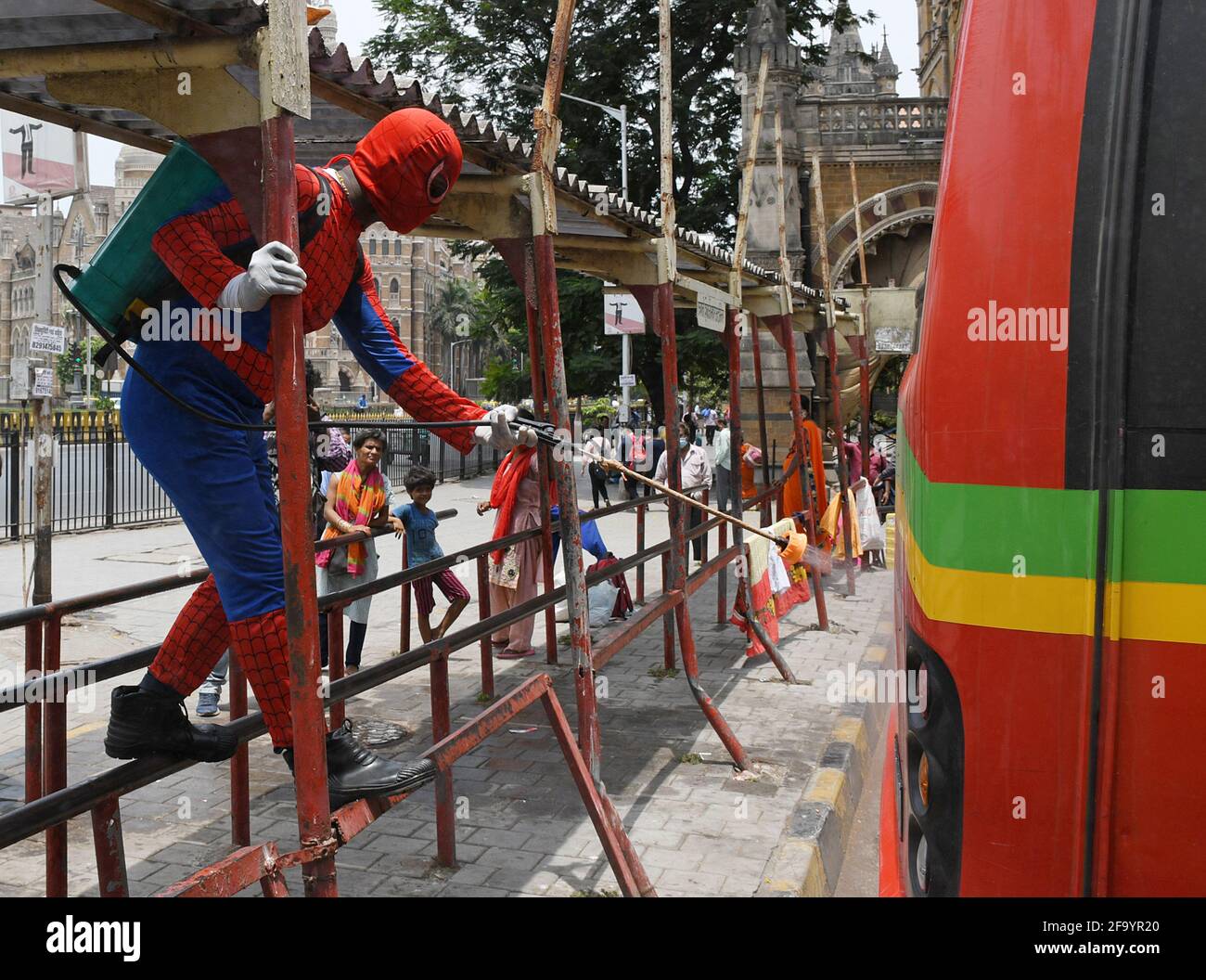 A man dressed as Spider Man sanitizes a public transport bus outside ...