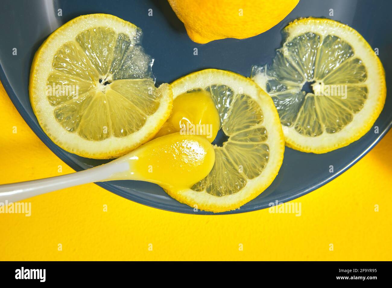 sliced fresh lemon and spoonful of honey in blue plate Stock Photo - Alamy