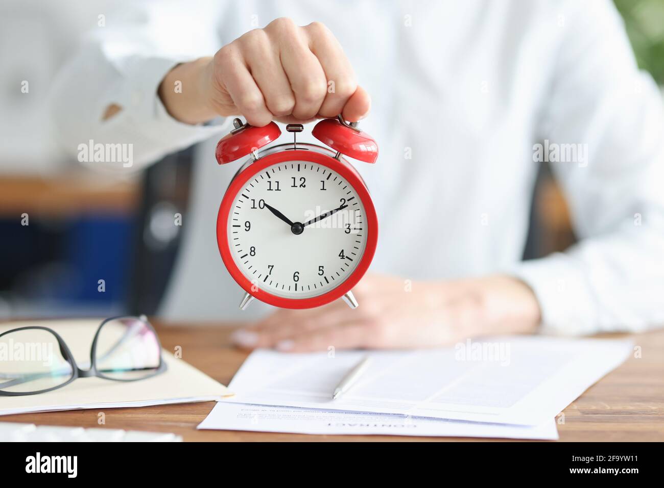 Red Alarm Clock In Hand Holding