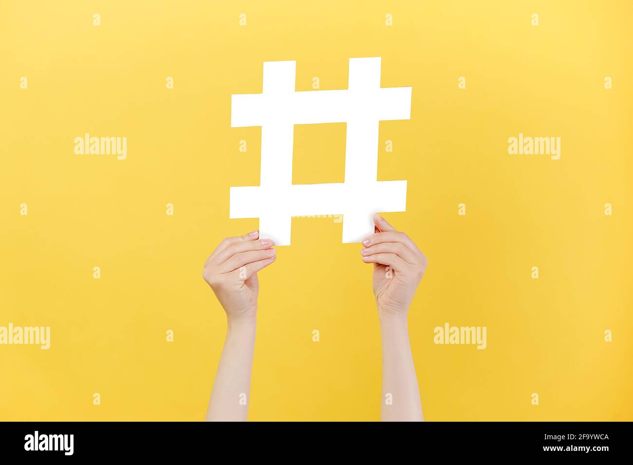 Cropped images of female hands holding large big white hashtag sign ...