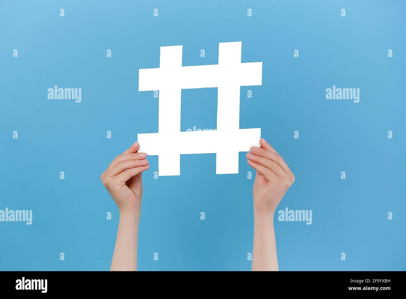Horizontal images of female hands holding large big white hashtag sign ...
