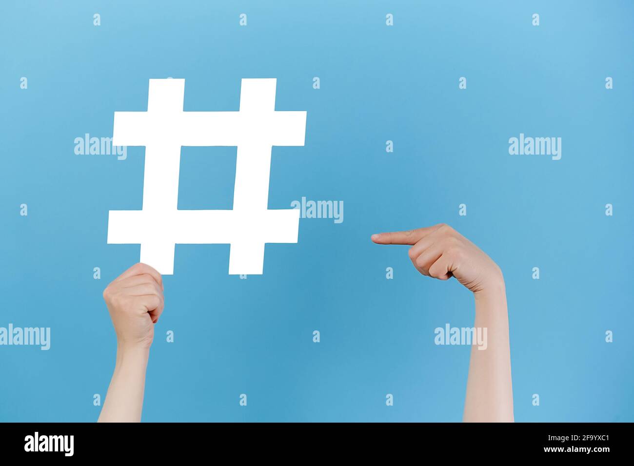 Horizontal images of female hands holding large big white hashtag sign ...