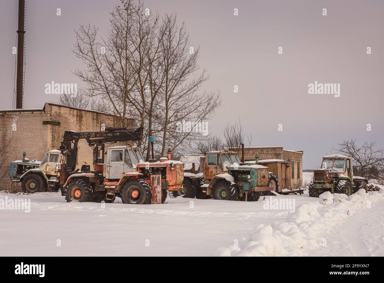 old rusty abandoned tractors in winter Stock Photo - Alamy