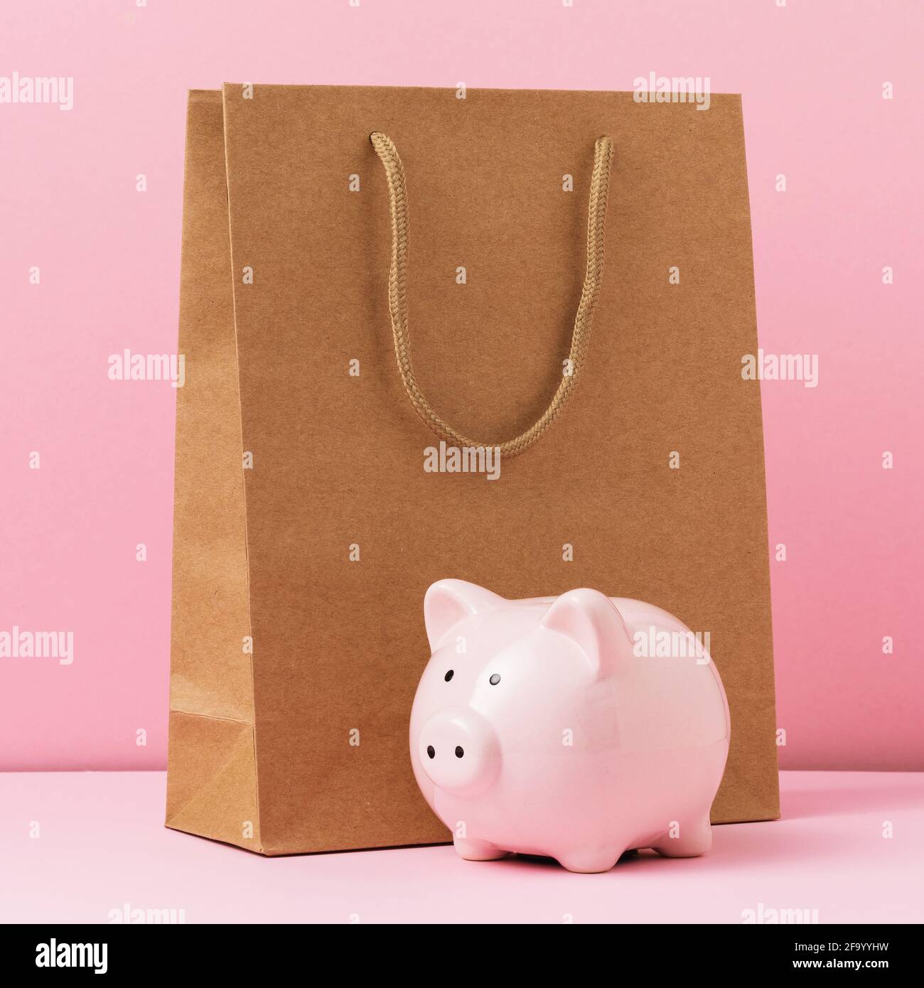 Blank paper bag and piggy bank on pink background Stock Photo - Alamy