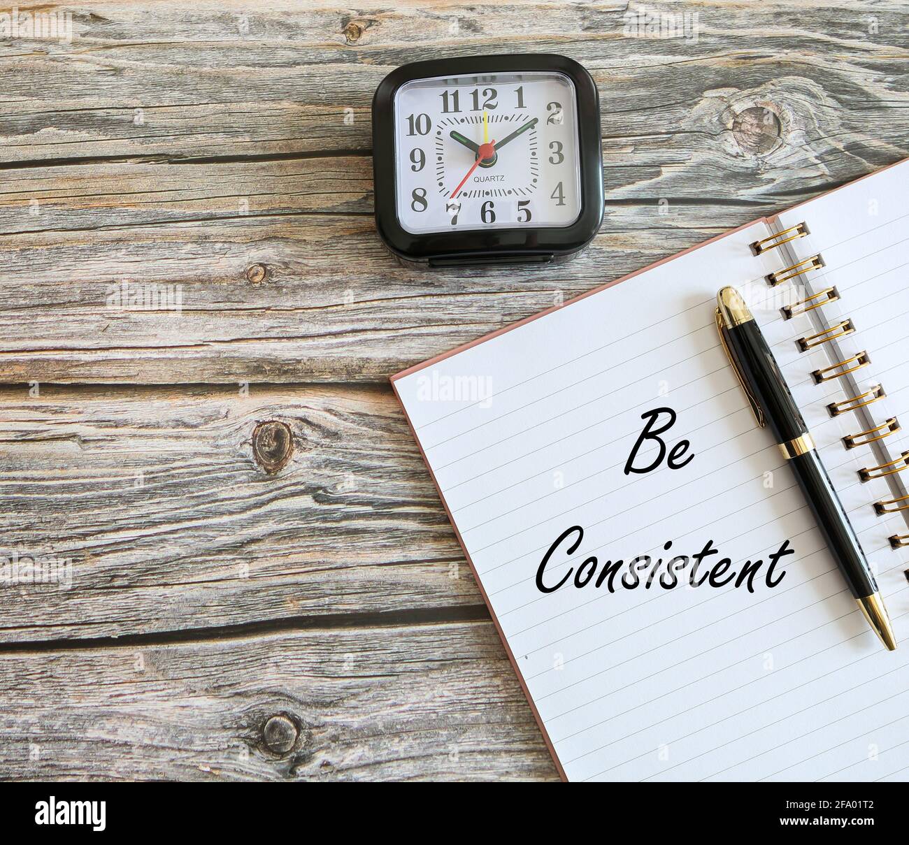 Be consistent written on a notebook Stock Photo - Alamy