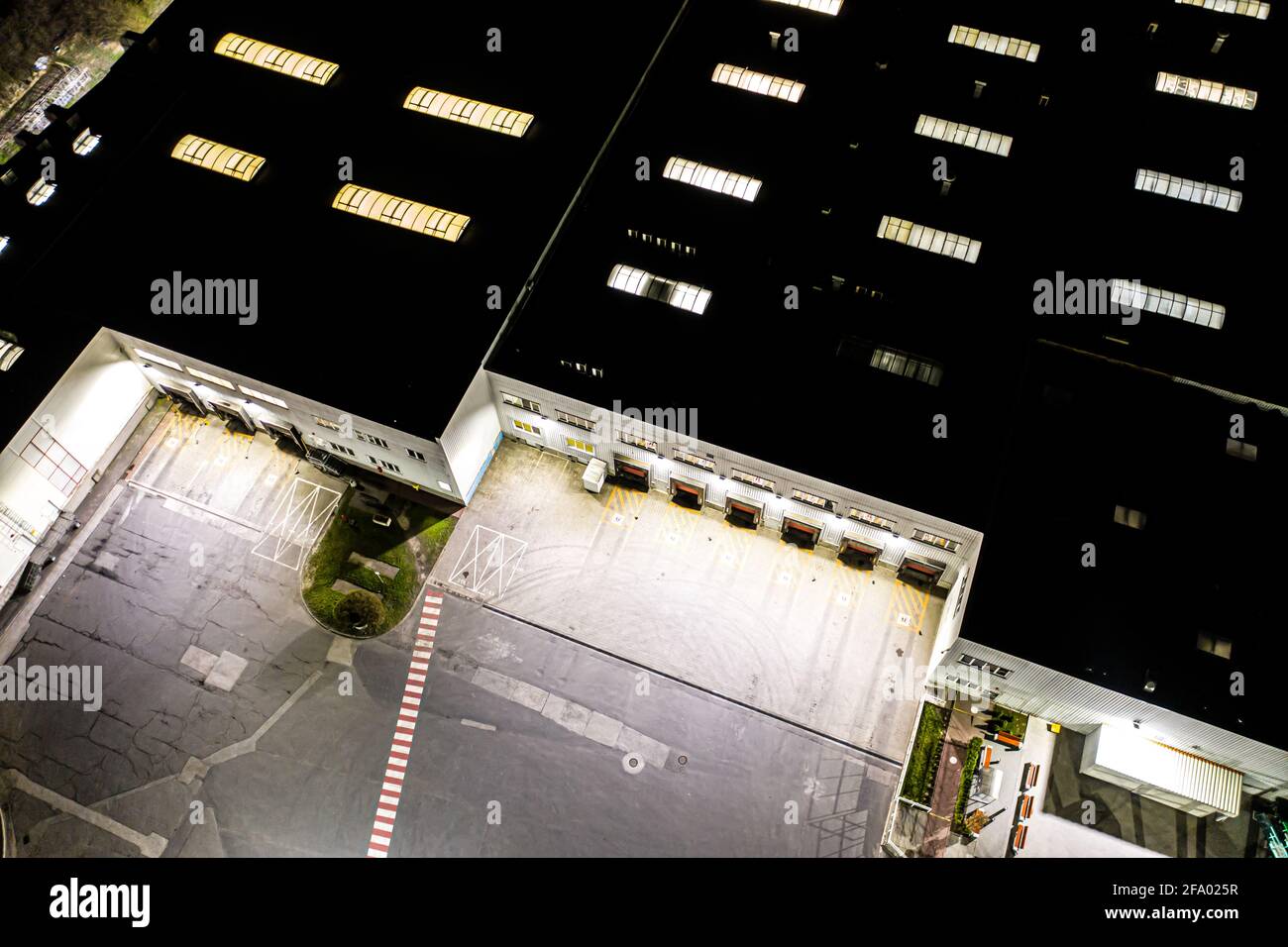 Aerial view of the trucks unloading at the logistic center. Night view ...