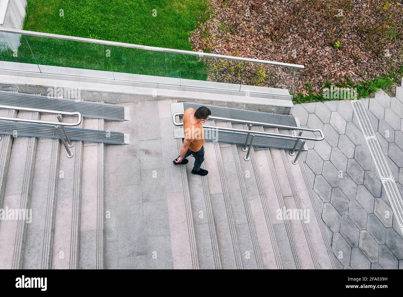 The man comes down the stairs. Concrete staircase with railings and ...