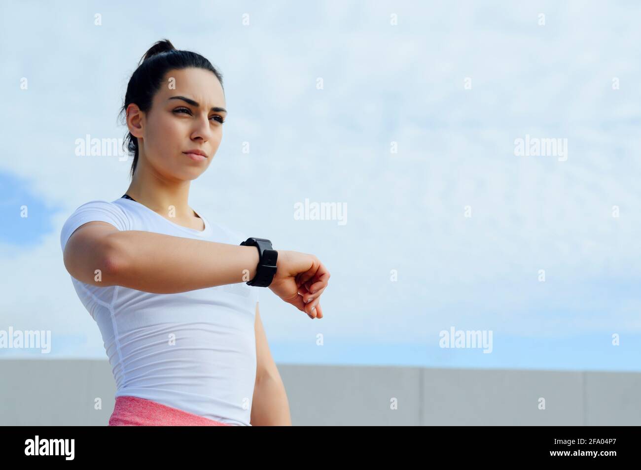 athlete woman runner looking at the time on the clock Stock Photo - Alamy
