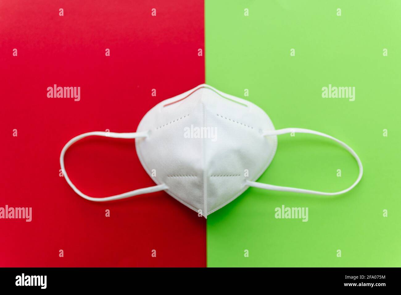 N95 respirator mask on red and green background with elastic ear bands ...