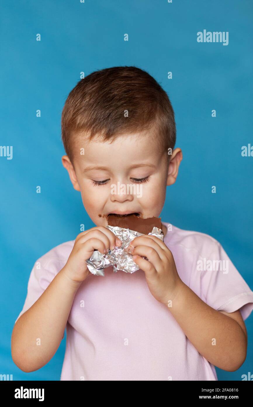 Happy boy with chocolate bar. Cute Little Boy Eating Chocolate Bar ...