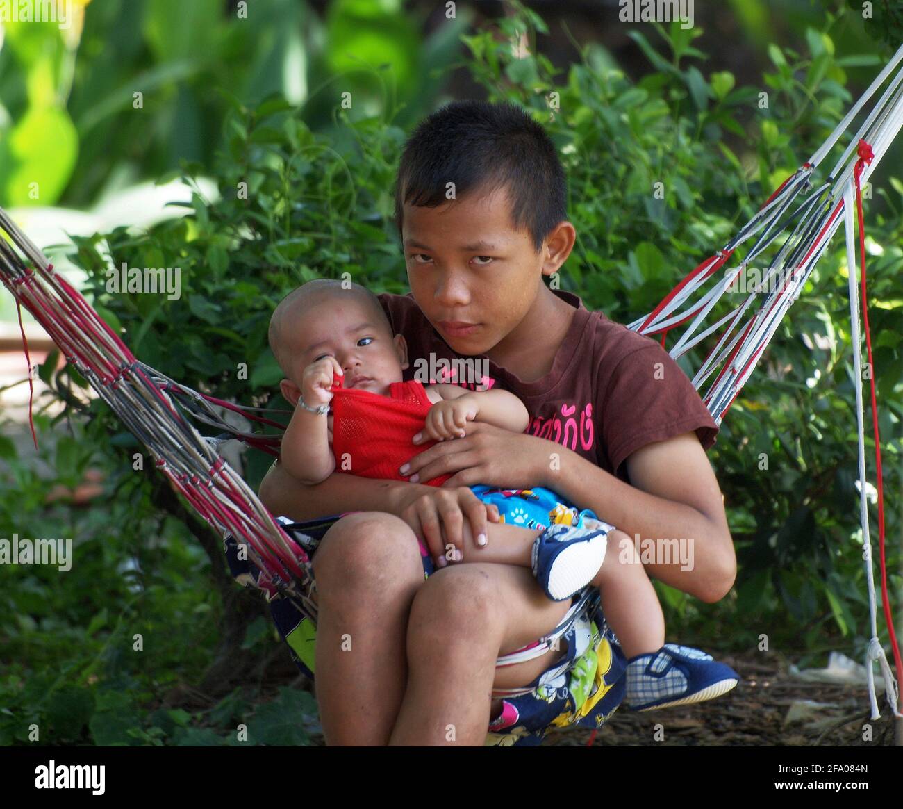 Siblings: An older brother takes care of his baby brother just outside ...