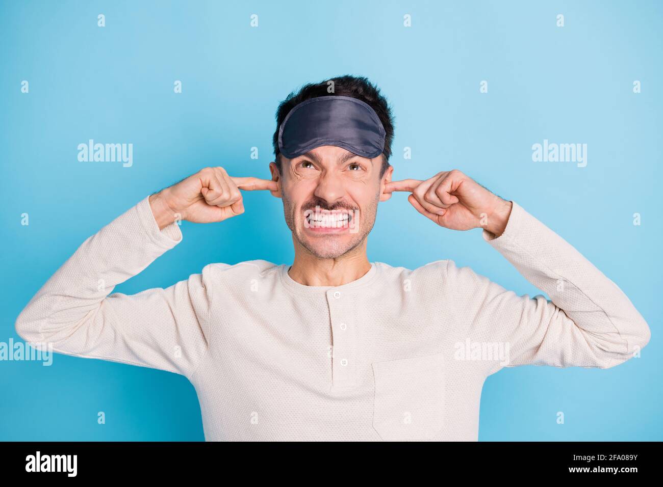 Portrait of wild evil crazy bored guy wearing eye mask closing ears ...