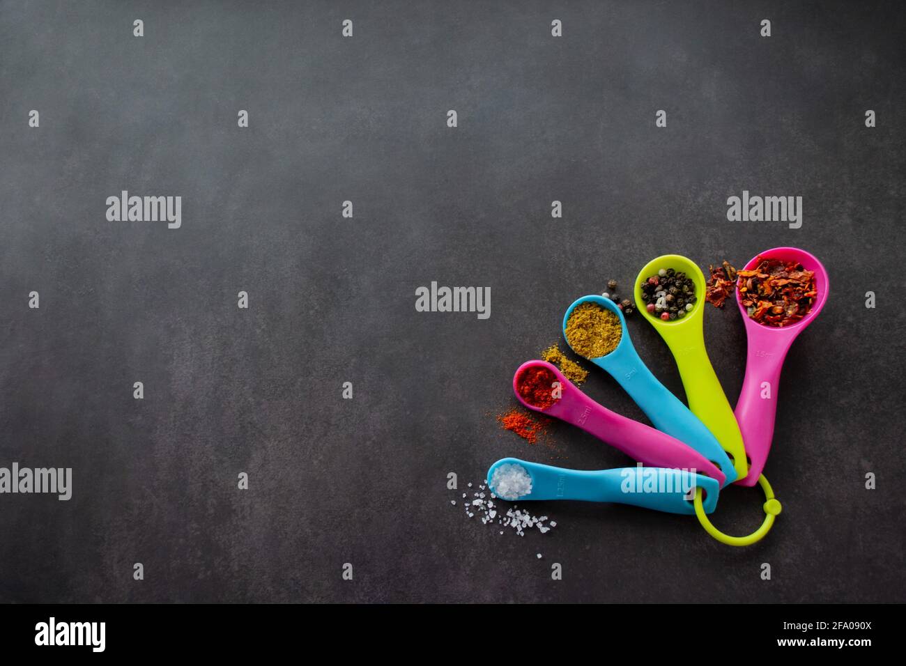 Multicolored measuring spoons of pink, blue and yellow-green colors and ...