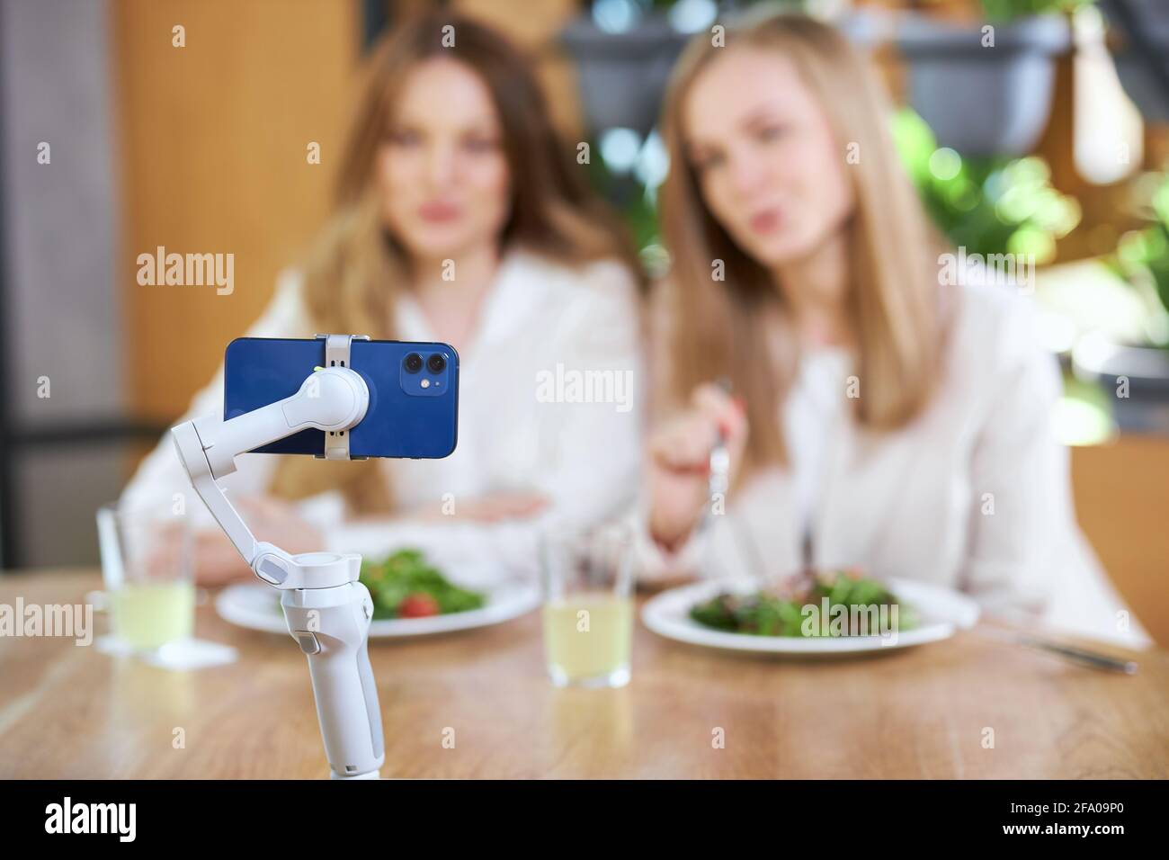 Two pretty girlfriends talking eating hi-res stock photography and ...
