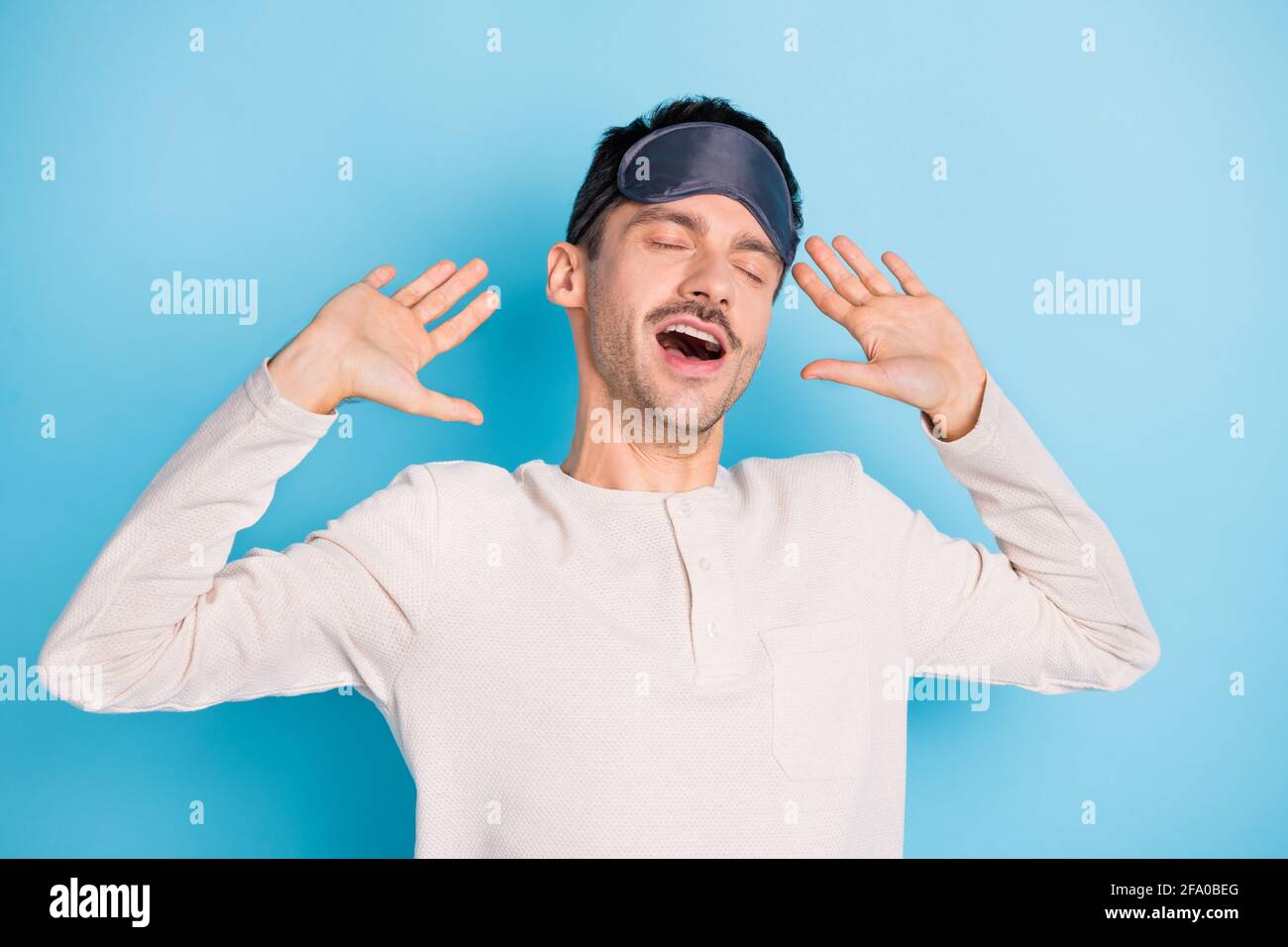 Portrait of nice sleepy guy wearing sleep mask stretching yawning good ...